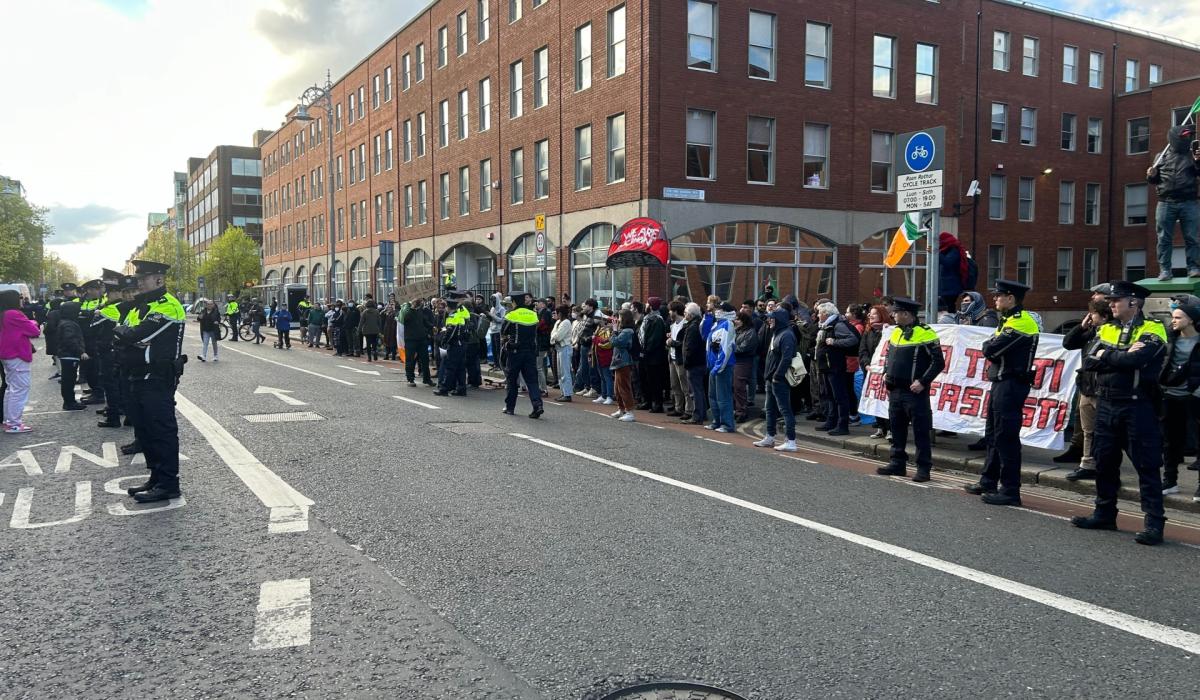 Hundreds line the streets as protesters standoff near migrant camp in ...